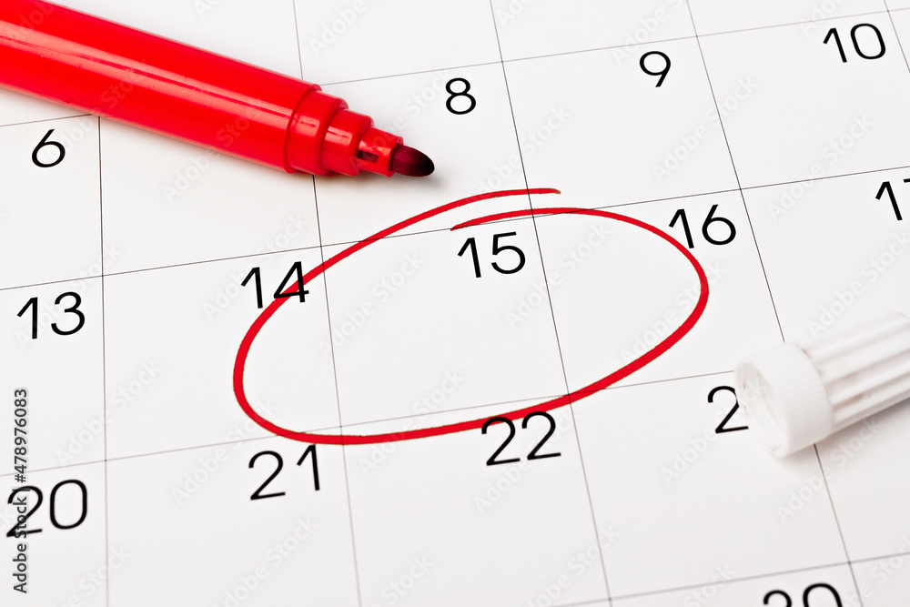 Calendar page with red pen close up. Focus on number 15 in calendar and ...