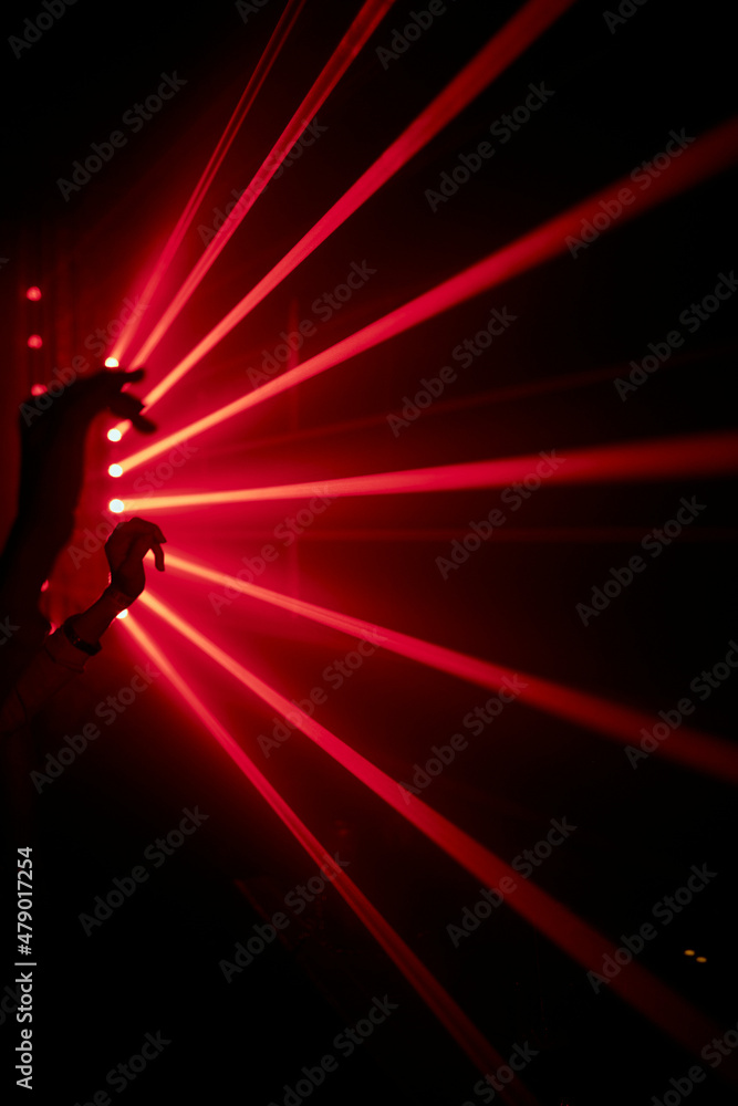 Bright red neon laser lights illuminate the darkness creating lines and ...