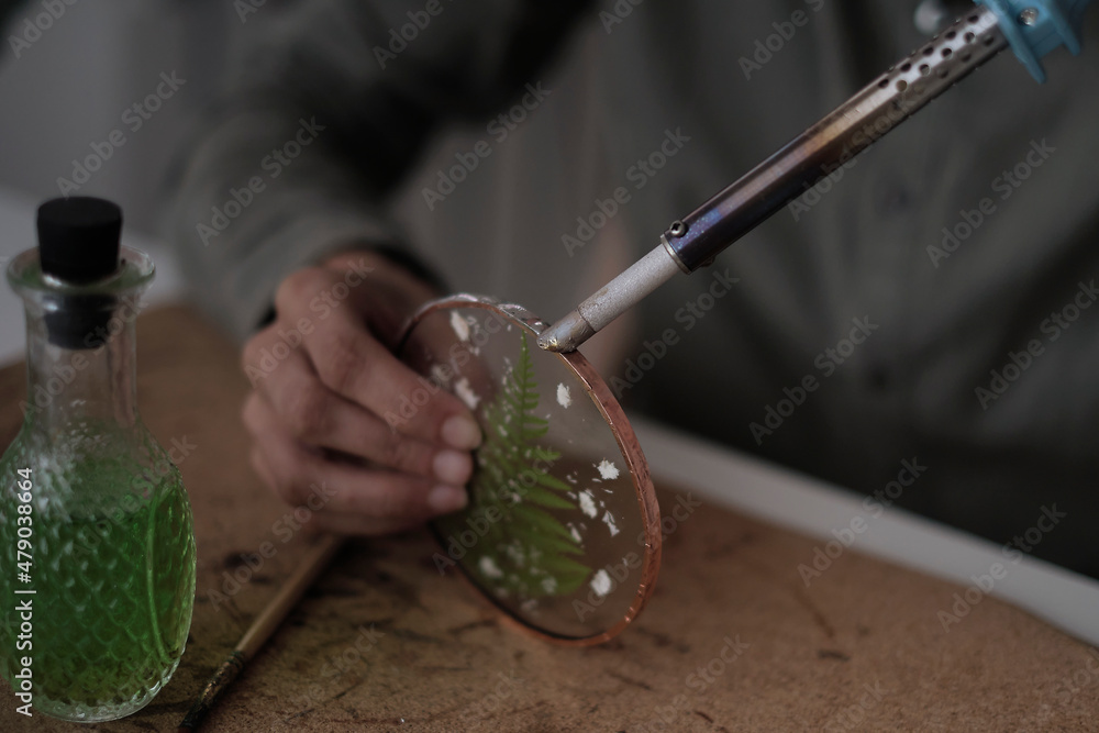 Stained glass maker works with colorful souvenirs. Female hands ...