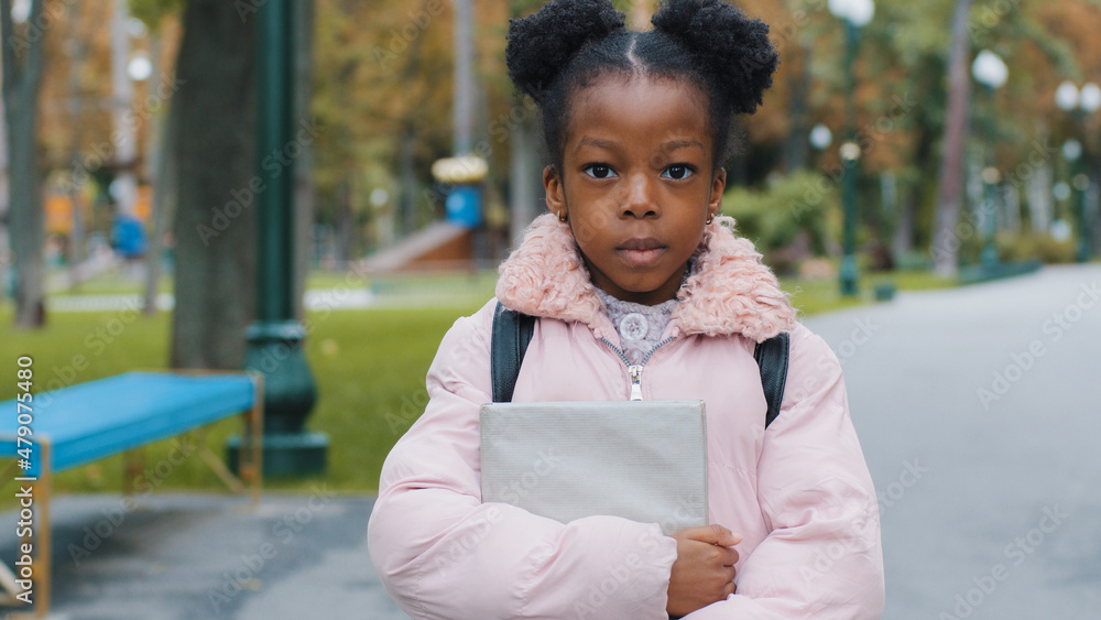 Close-up afro child standing with book in hand in park schoolgirl ...