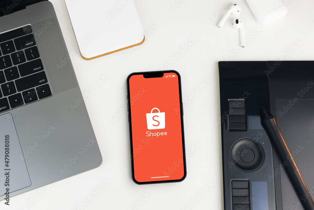 Shopee app on the smartphone screen on white background table. Office ...