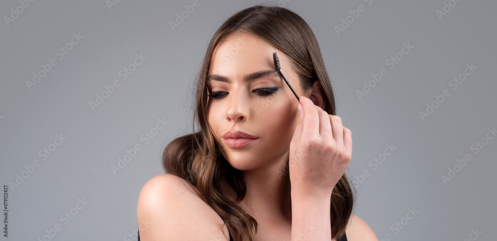 Brunette woman eye with beautiful eyebrows. Perfect shaped brow, eyelashes with brow gel brush ...