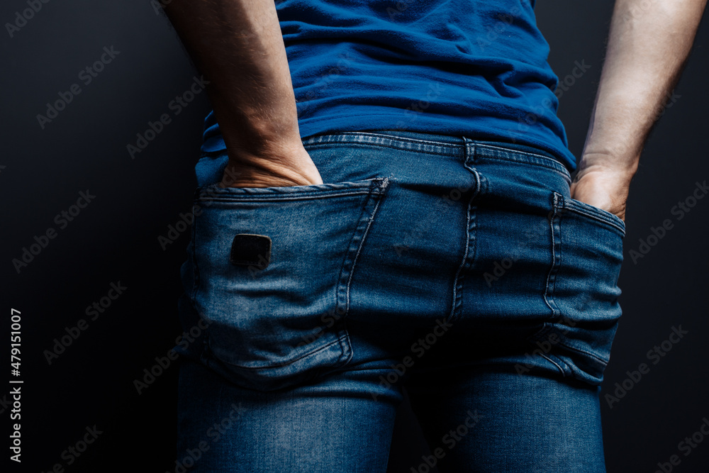 slender guy with an elastic ass. a man in jeans on a black background ...