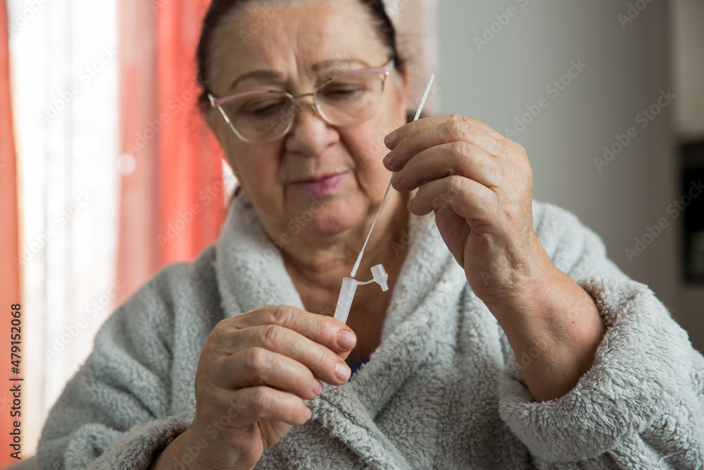 Senior woman taking Rapid Antigen test for self-diagnostic SARS-CoV-2 ...