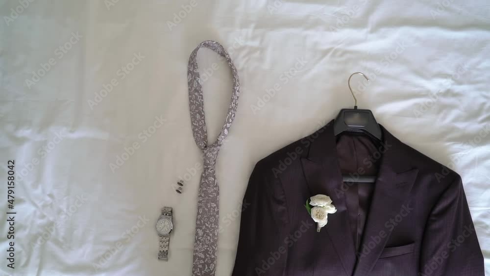Male suit on bed in the bedroom. Black tuxedo jacket with white rose ...
