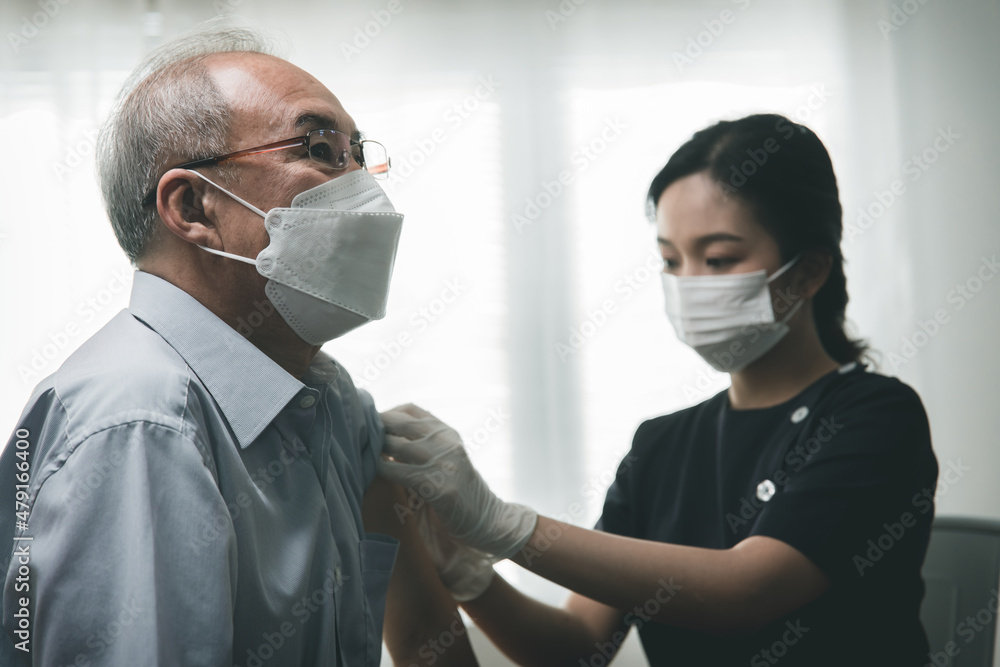 old Asian man vaccinate with doctor woman, giving shot to senior ...