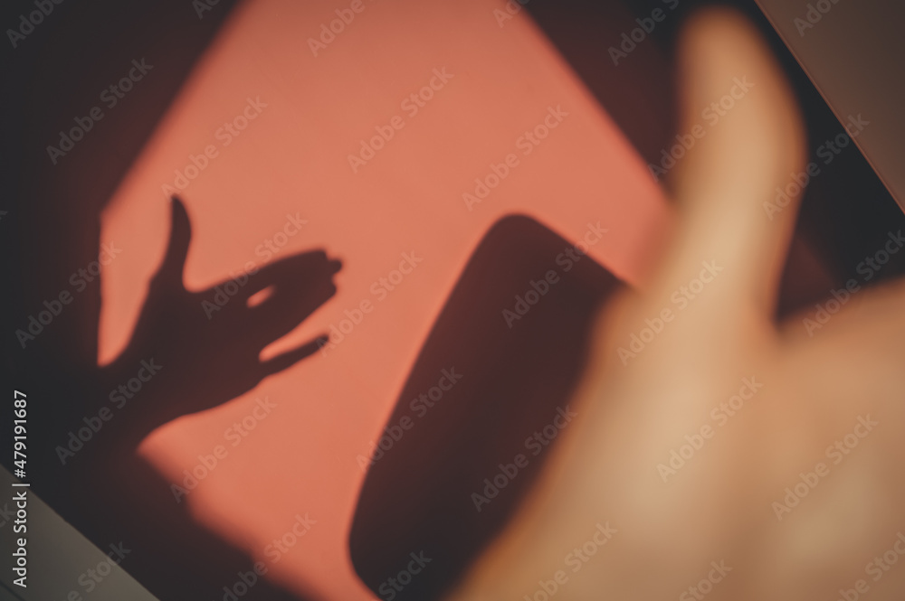 Blurred shadow on the wall from the hand in the shape of a dog's head ...