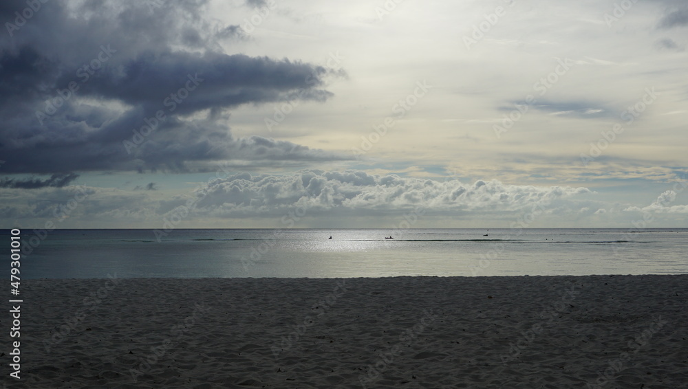 Mild sunset with soft fluffy clouds at a quiet beach in Saipan ...
