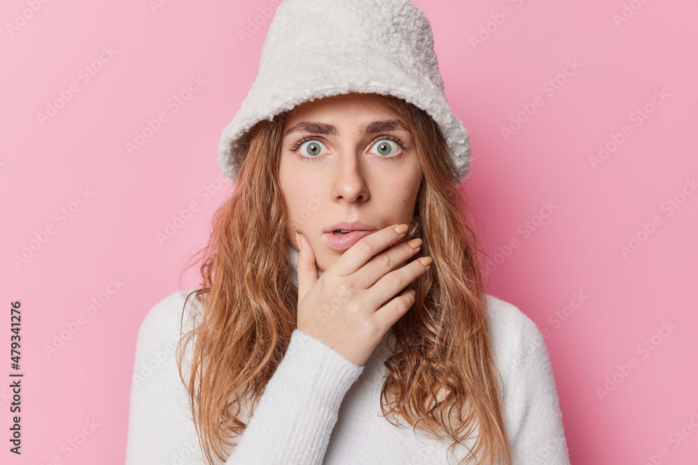 Scared fearful woman holds chin stares with eyes full of amazement ...