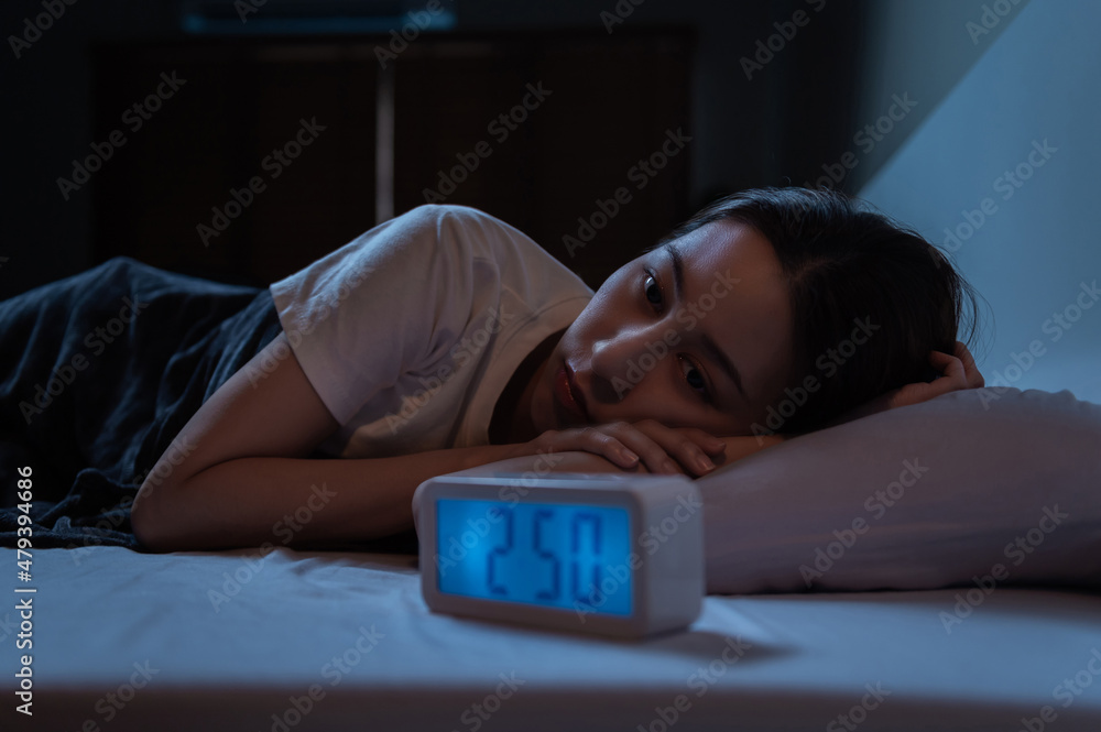 Young Asian woman suffer from insomnia can't sleep at night awaken from ...