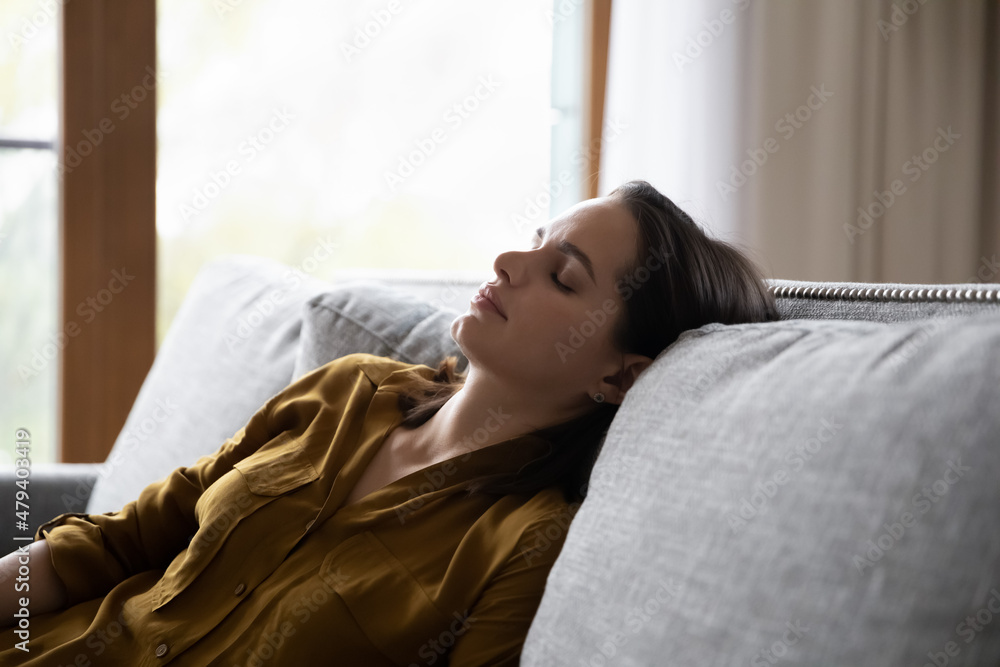 Tired millennial young woman sleeping in sitting position on couch ...