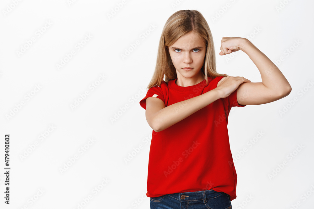 Girl power. Cute teen daughter, small child shows her muscles, biceps ...