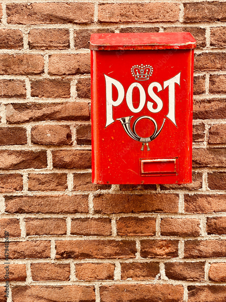 Traditional old bright red metal post box with word and picture of horn ...