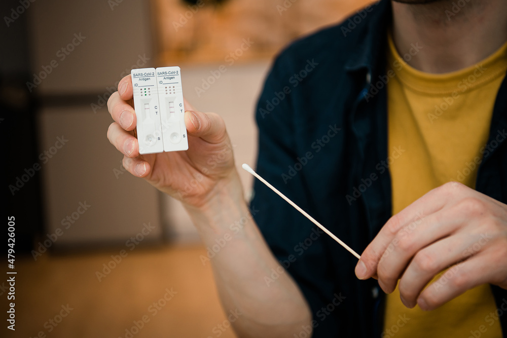 Home test for COVID-19. Positive and negative test results. Man using ...