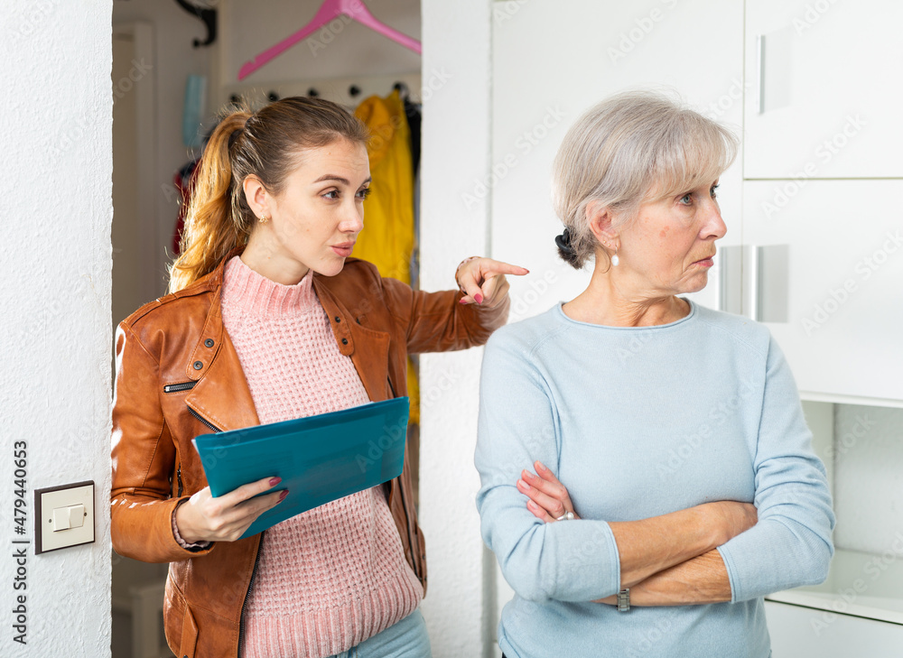 Angry young female householder demanding upset older woman to pay ...