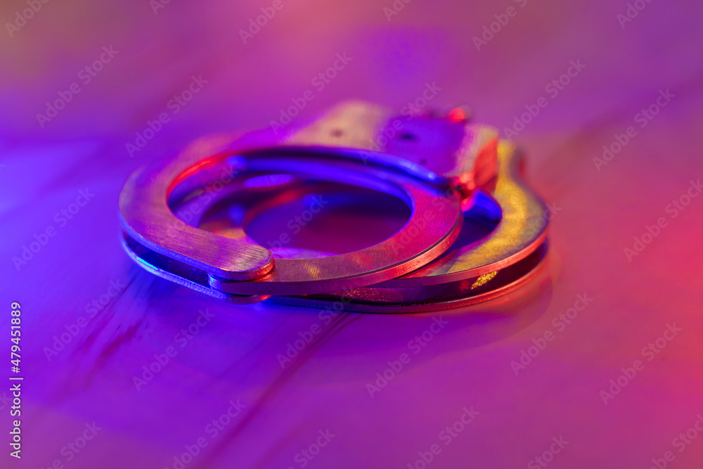 Legal law of handcuffs with the flashing red and blue police lights ...
