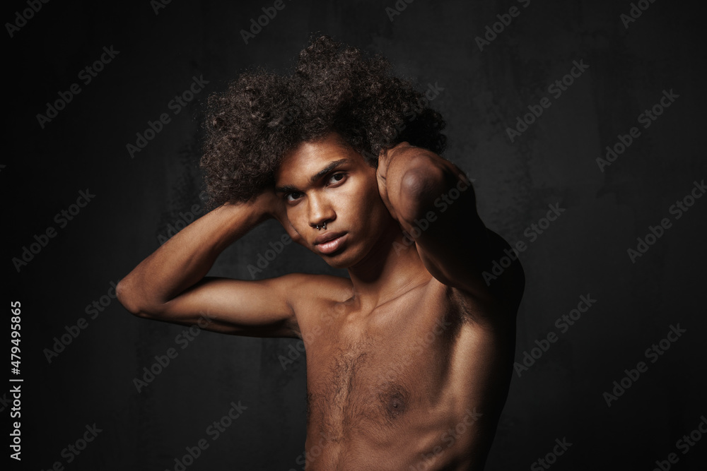 Shirtless black man with piercing holding his head and looking at ...