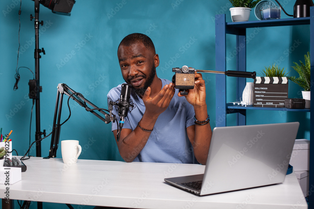 Vlogger explaining features of videography stabilization device with ...