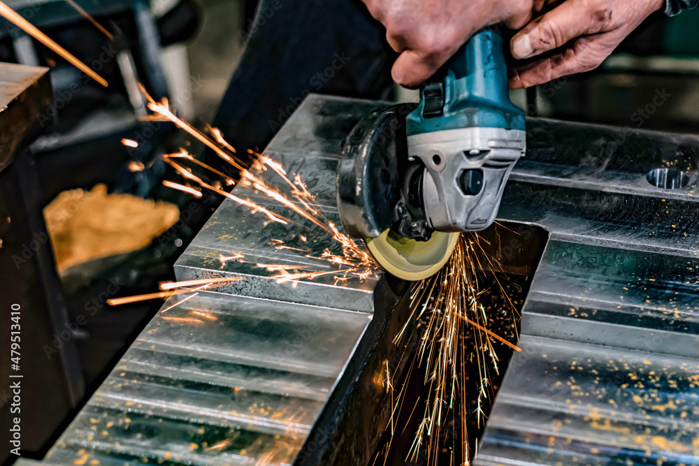 Grinding burrs and metal with an angle grinder with sparks. Stock Photo ...