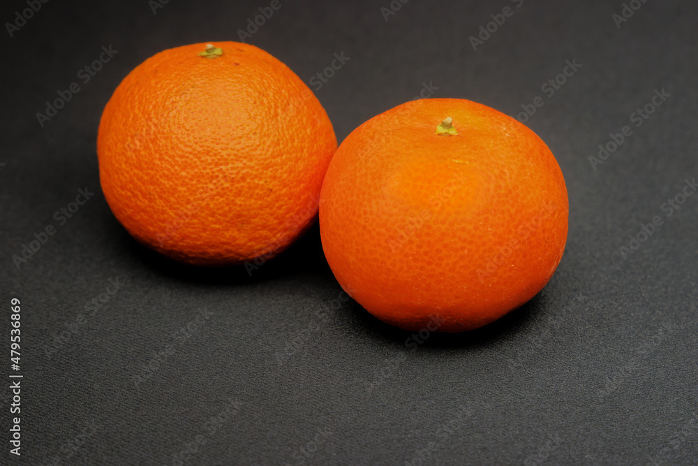 Clémentines en gros plan sur un fond noir. C'est un agrume, fruit du ... Clémentines en gros plan sur un fond noir. C'est un agrume, fruit du ...