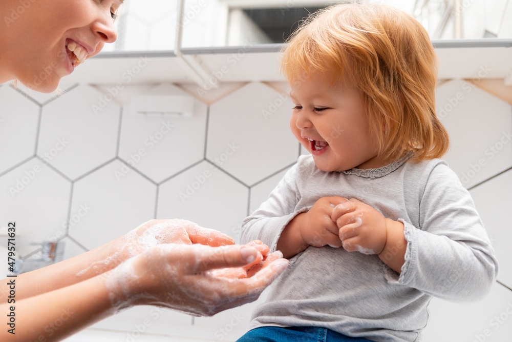 Child learning a hygienic routine. A happy little girl learns from a ...