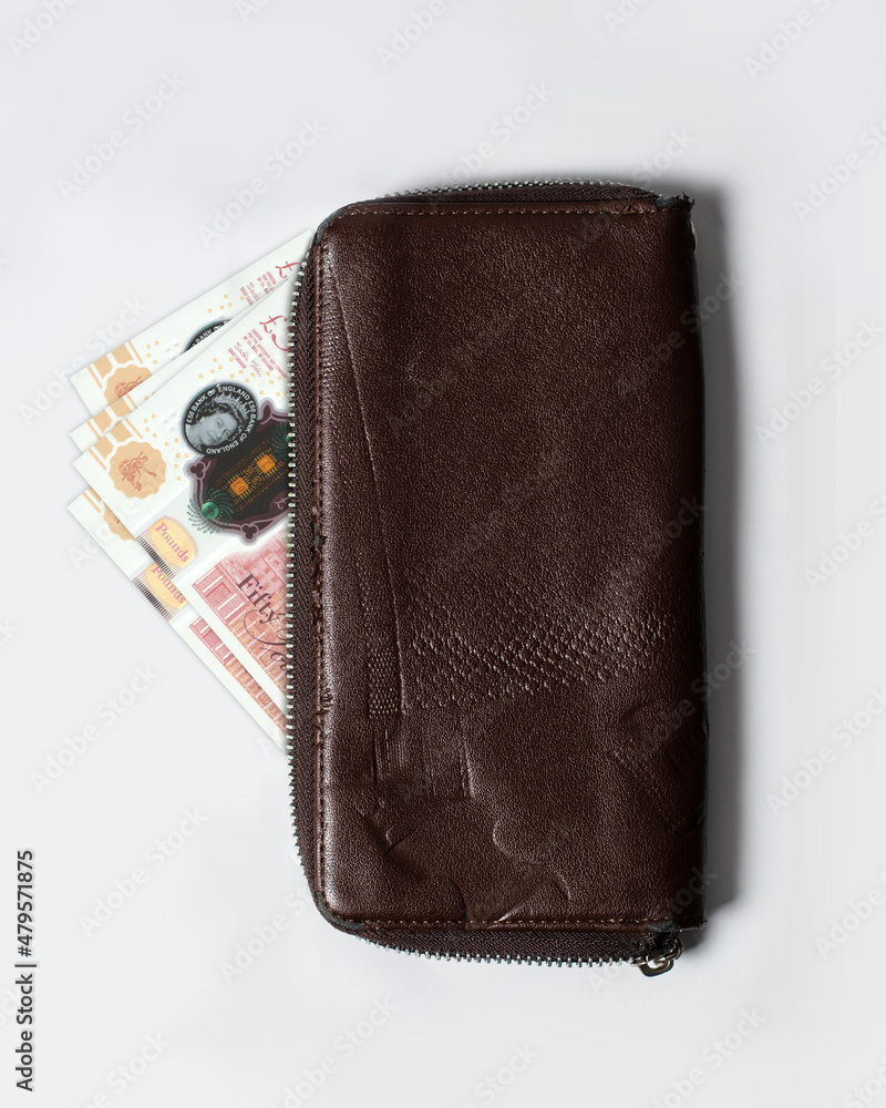 50 pound notes inside a wallet. Pounds popping out of a brown leather ...
