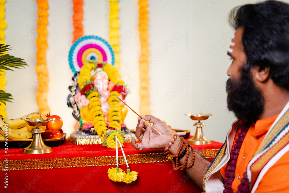 Focus on hand Holy god man or Indian priest offering aarti by chanting ...