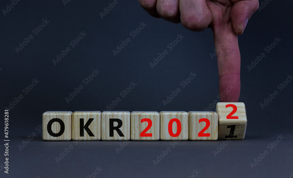 OKR, objectives and key results symbol. Businessman turns a cube with words OKR 2021 and OKR ...