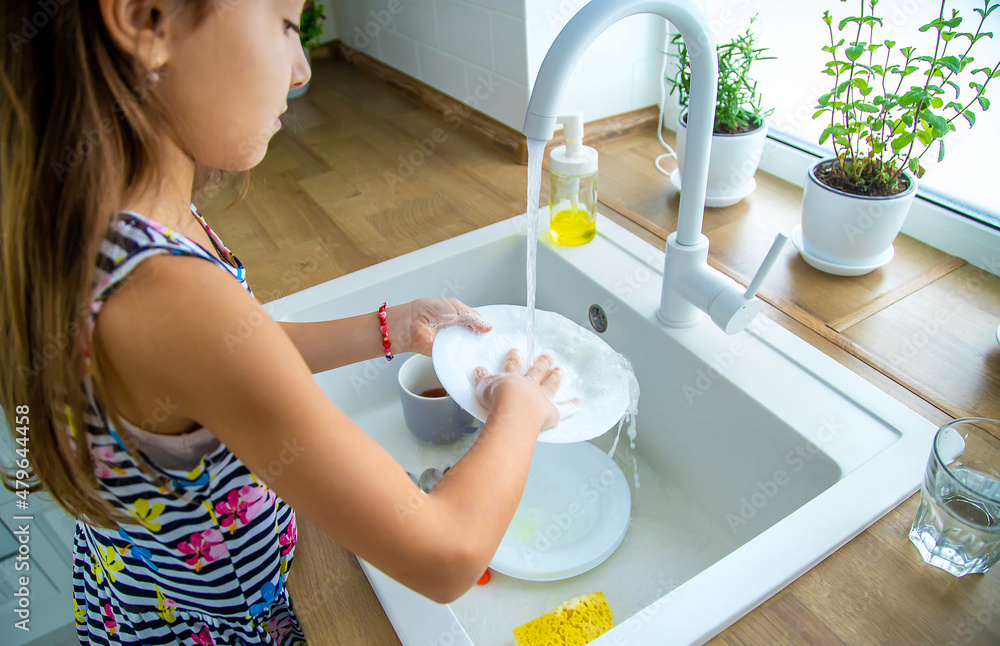 Children wash dishes in the kitchen. Selective focus. Stock Photo ...