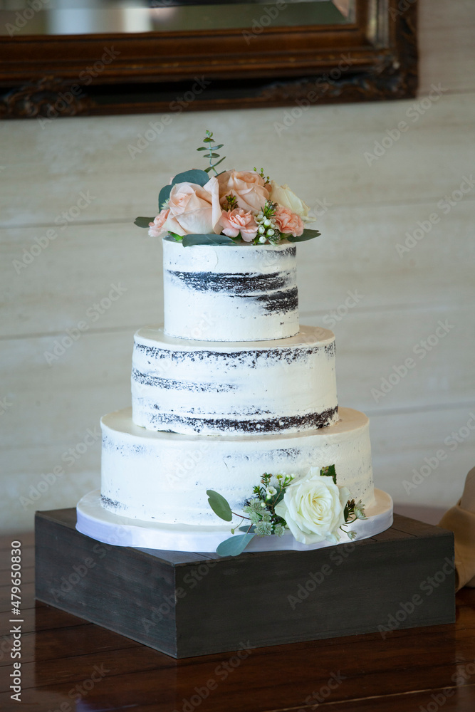 Poster Beautiful three tiered wedding cake with roses and dirty icing ...