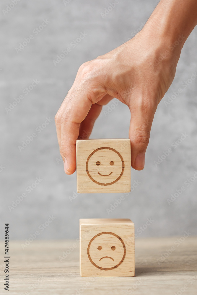 hand holding smile face block. Customer choose Emoticon for user ...