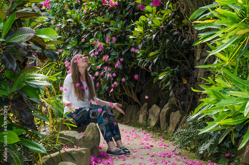 Caucasian white girl throwing flowers blossom over her head in ...