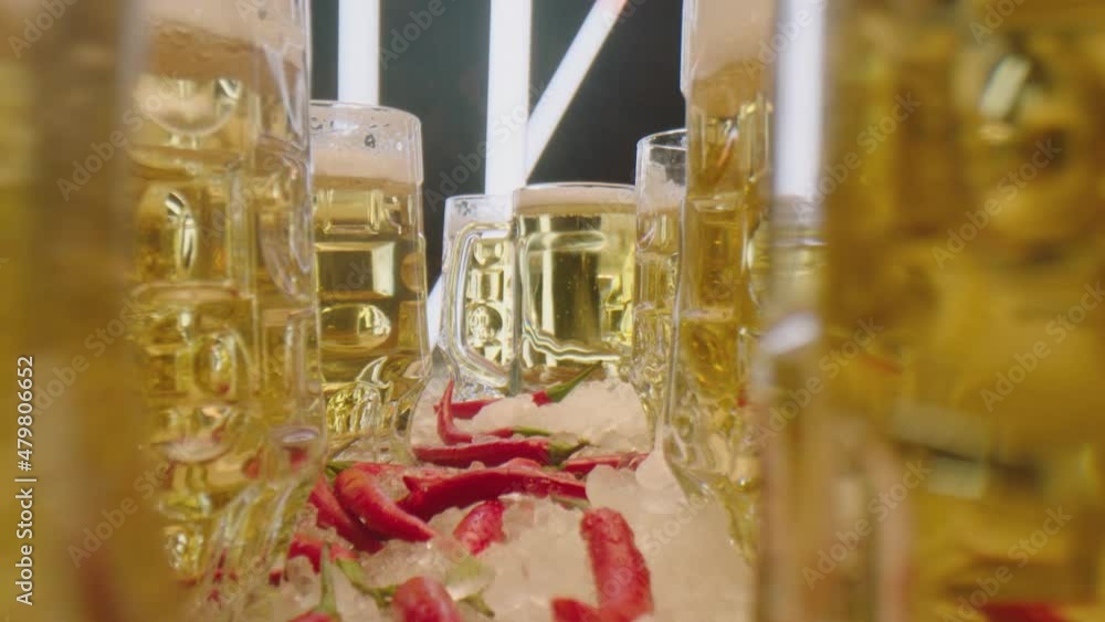 Row of many glasses full of light draft beer . Foam pouring from cup ...