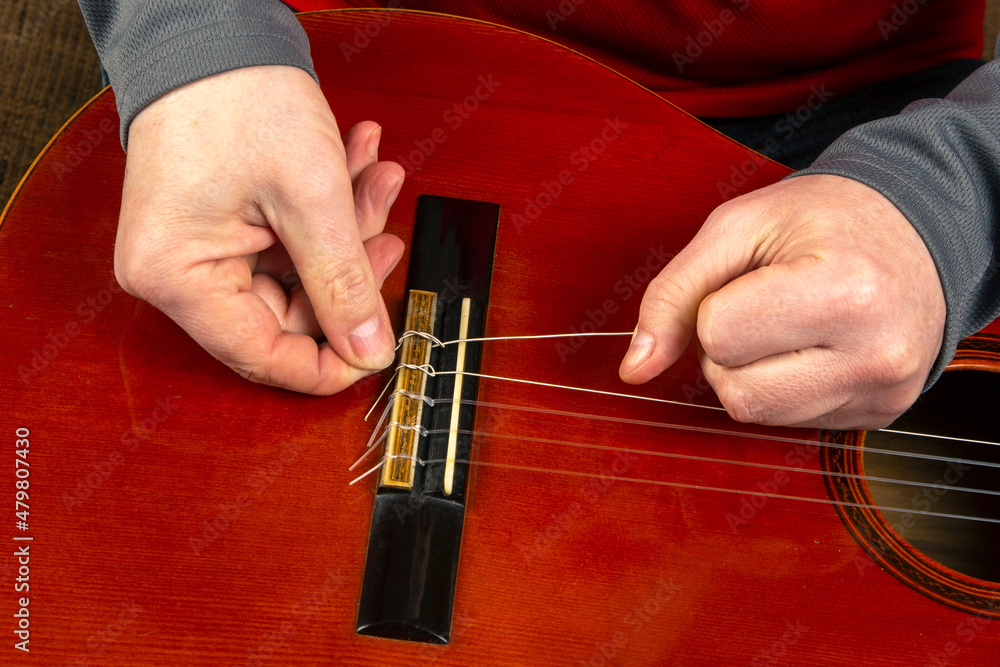 replacement and insertion of nylon strings in a classical guitar ...