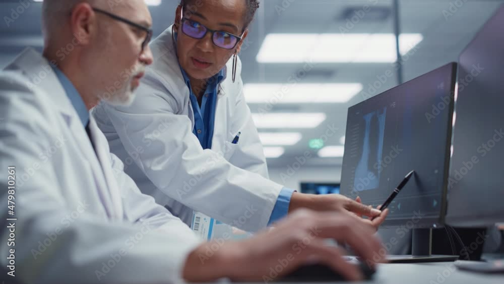 Medical Hospital: Two Doctors Talk and Use Computer, Discuss Tests ...