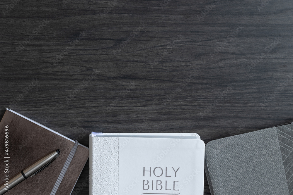 border of bible and journal on a dark wood background with copy space ...