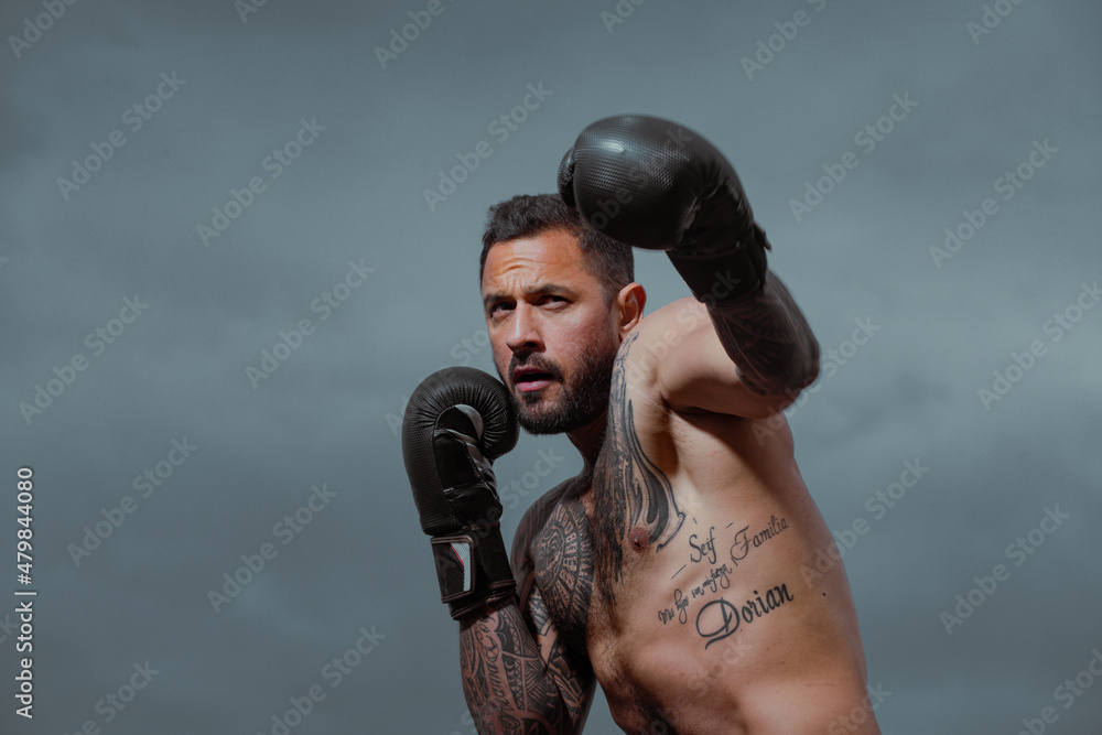 Boxer in a fight. Fist fight. Strong man with tattooed body boxing ...