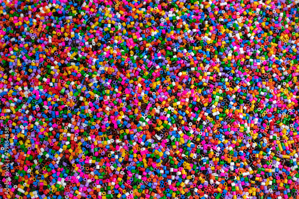 Small cylindrical pieces of plastic of multiple colors creating a ...