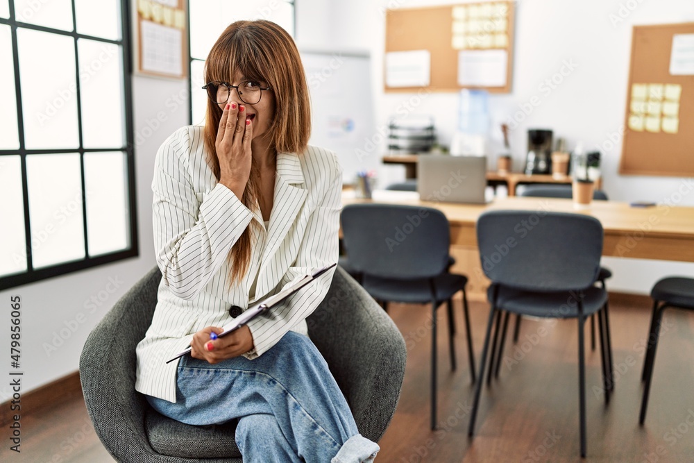 Hispanic business woman working at the office laughing and embarrassed ...
