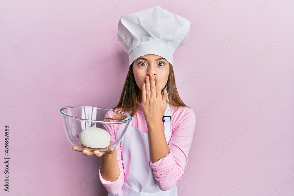 Beautiful brunette little girl wearing chef hat holding bread dough ...