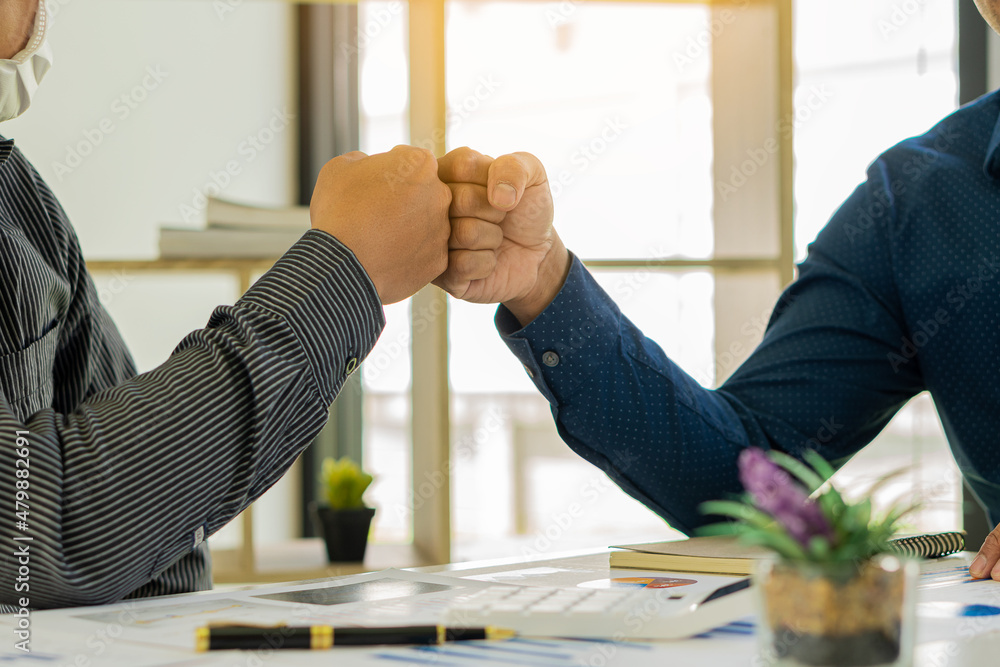 Two young businessmen use fists or punches to punch each other. After ...