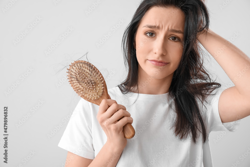 Young woman with hair loss problem on light background Stock Photo ...