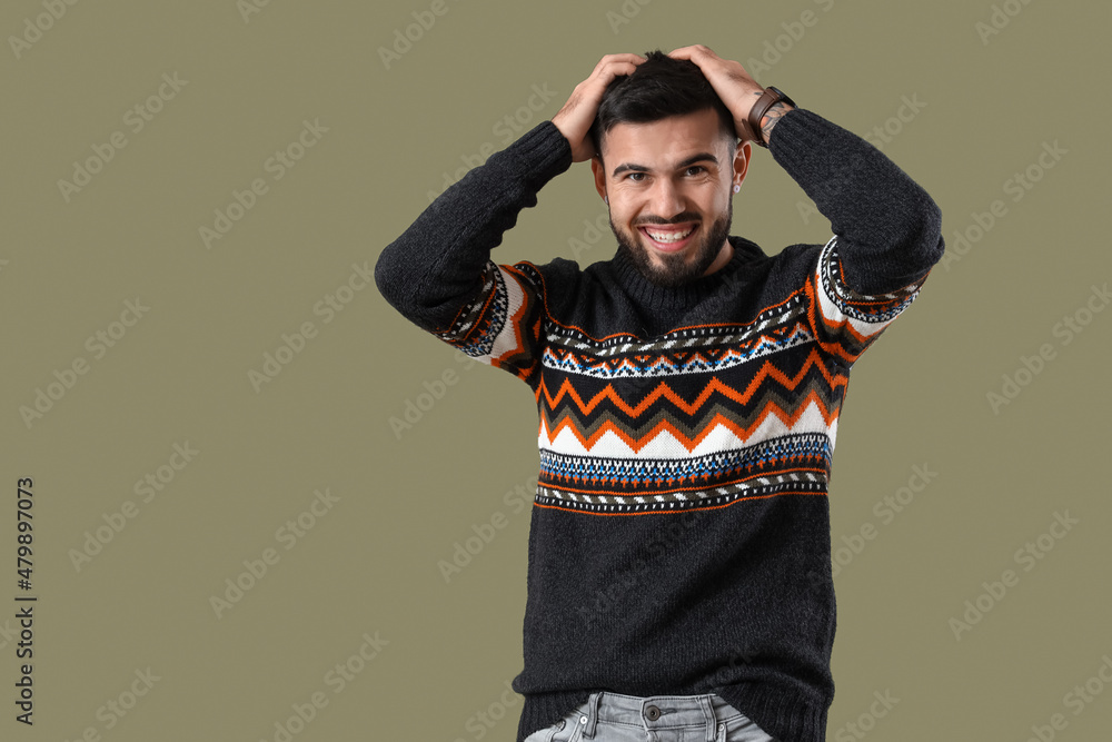 Handsome young man in warm sweater on color background Stock Photo ...