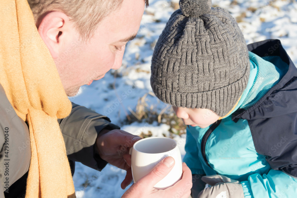 Dad and son in nature in winter drinking hot tea from a mug. Stock ...
