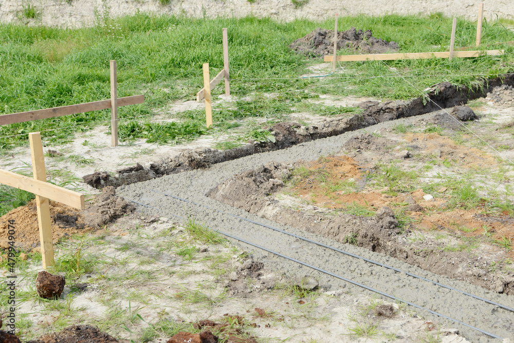 Filling strip foundation with concrete at the construction site. start ...