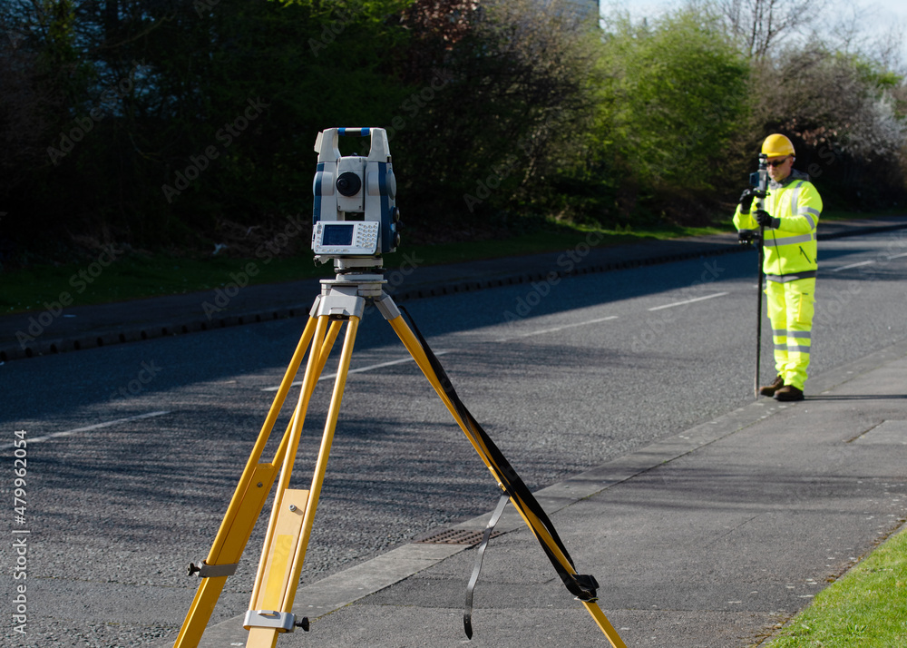 Site engineer doing road survey using modern robotic total station EDM ...