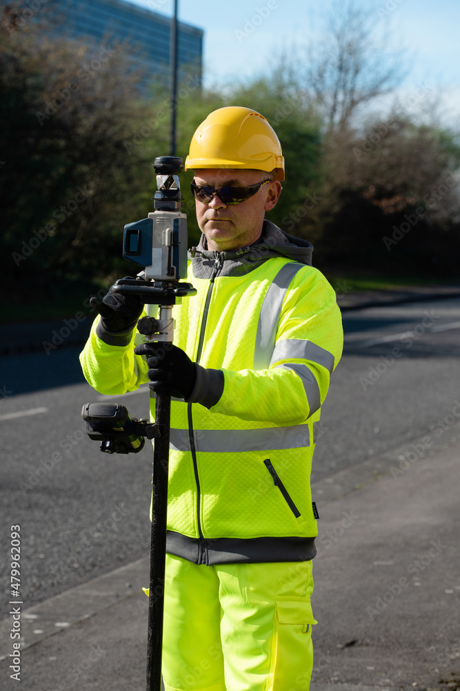 Site engineer doing road survey using modern robotic total station EDM ...