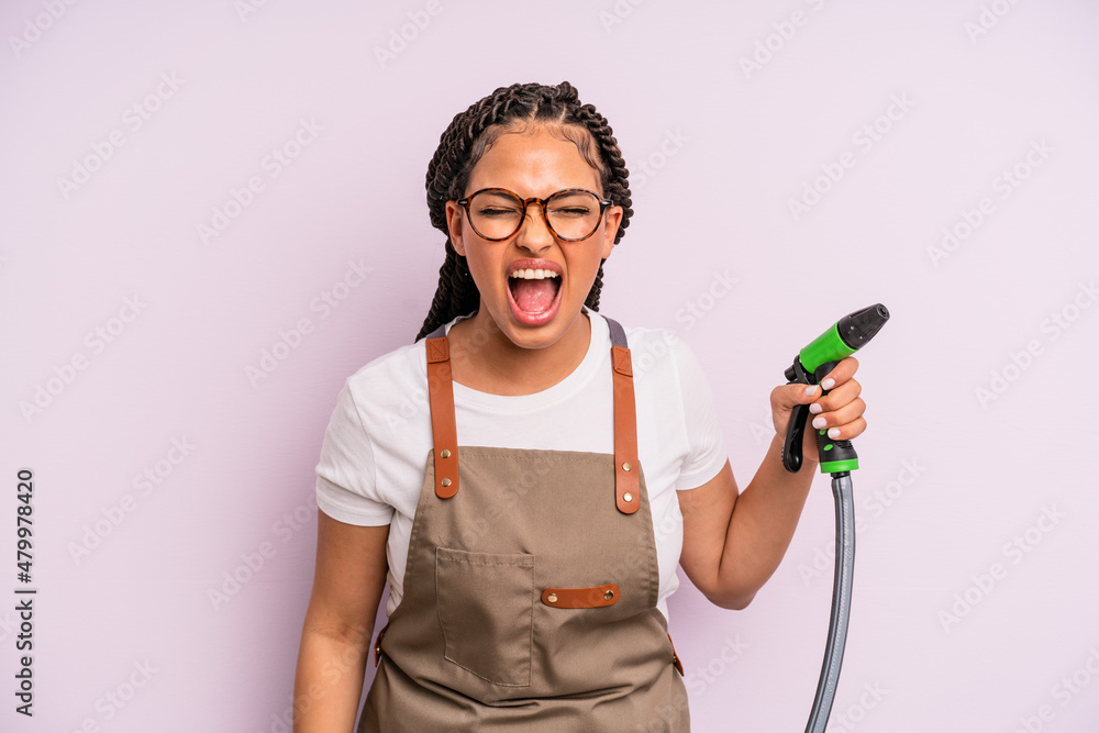 afro black woman shouting aggressively, looking very angry. gardener ...