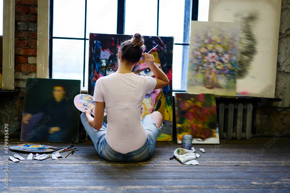 Back view of talented female artist with palette for mixing acrylic ...