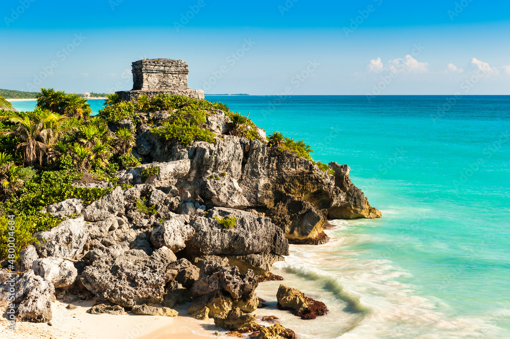 Ruins of the ancient Mayan city of Tulum in Mexico taken on warm summers day with clear blue ...